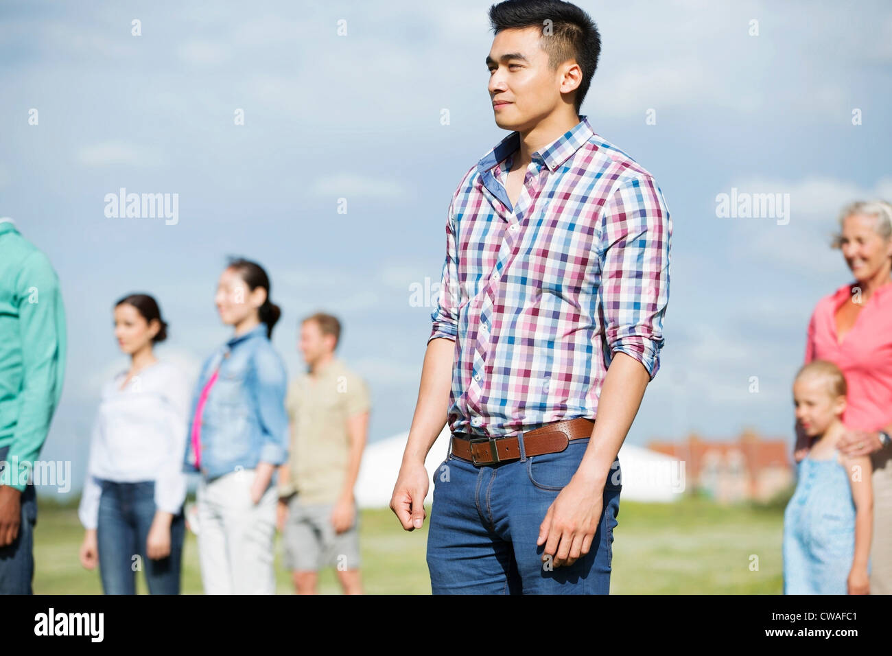 Young man standing in front of group of people outdoors Stock Photo - Alamy
