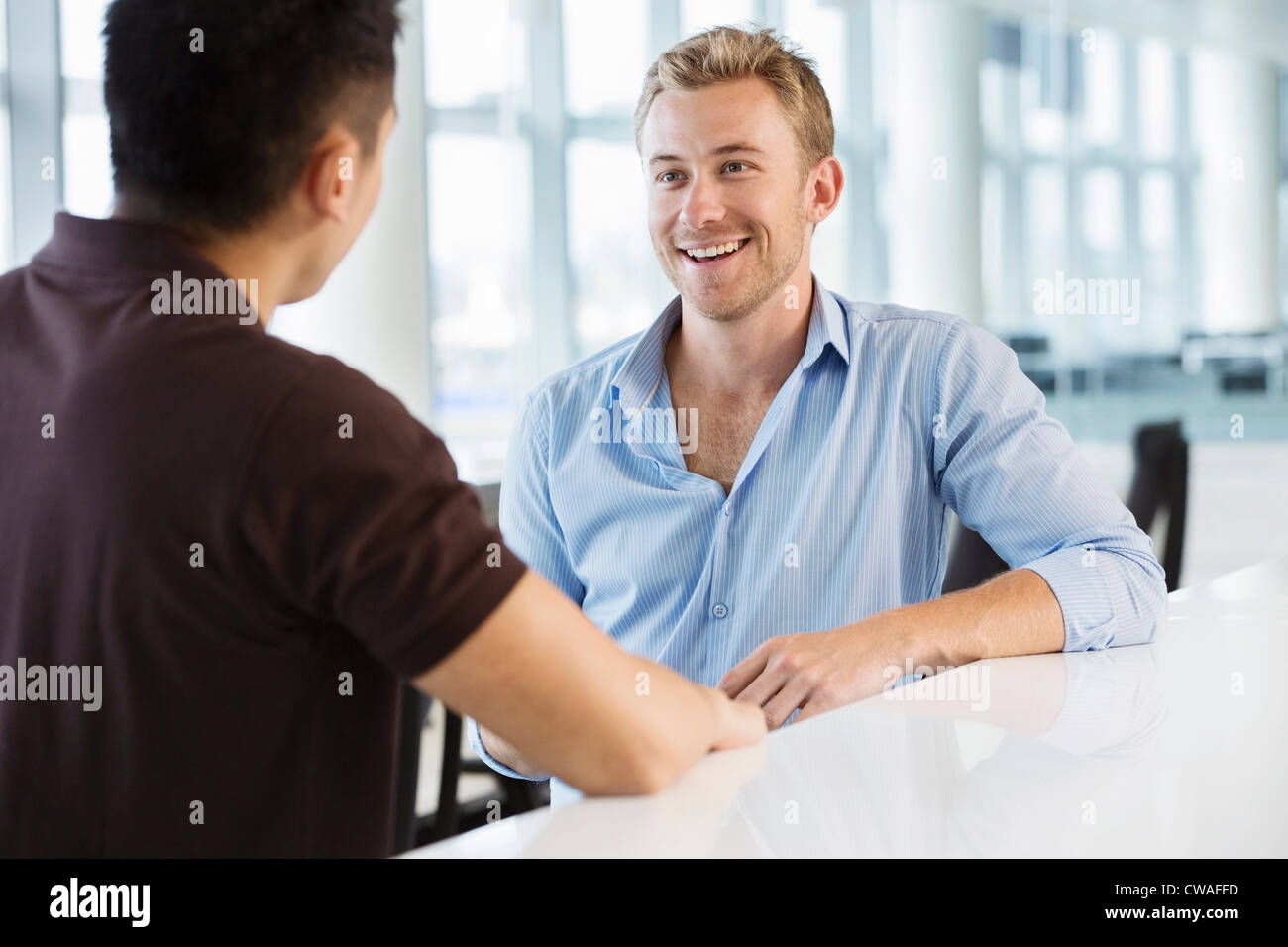 Two young businessmen talking Stock Photo - Alamy
