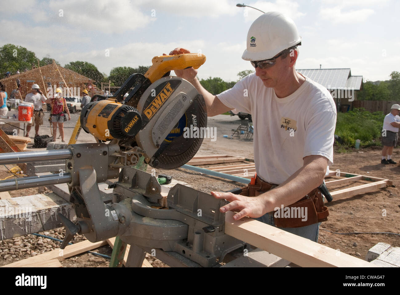 Company employees volunteer their time use miter saw, help build an ...