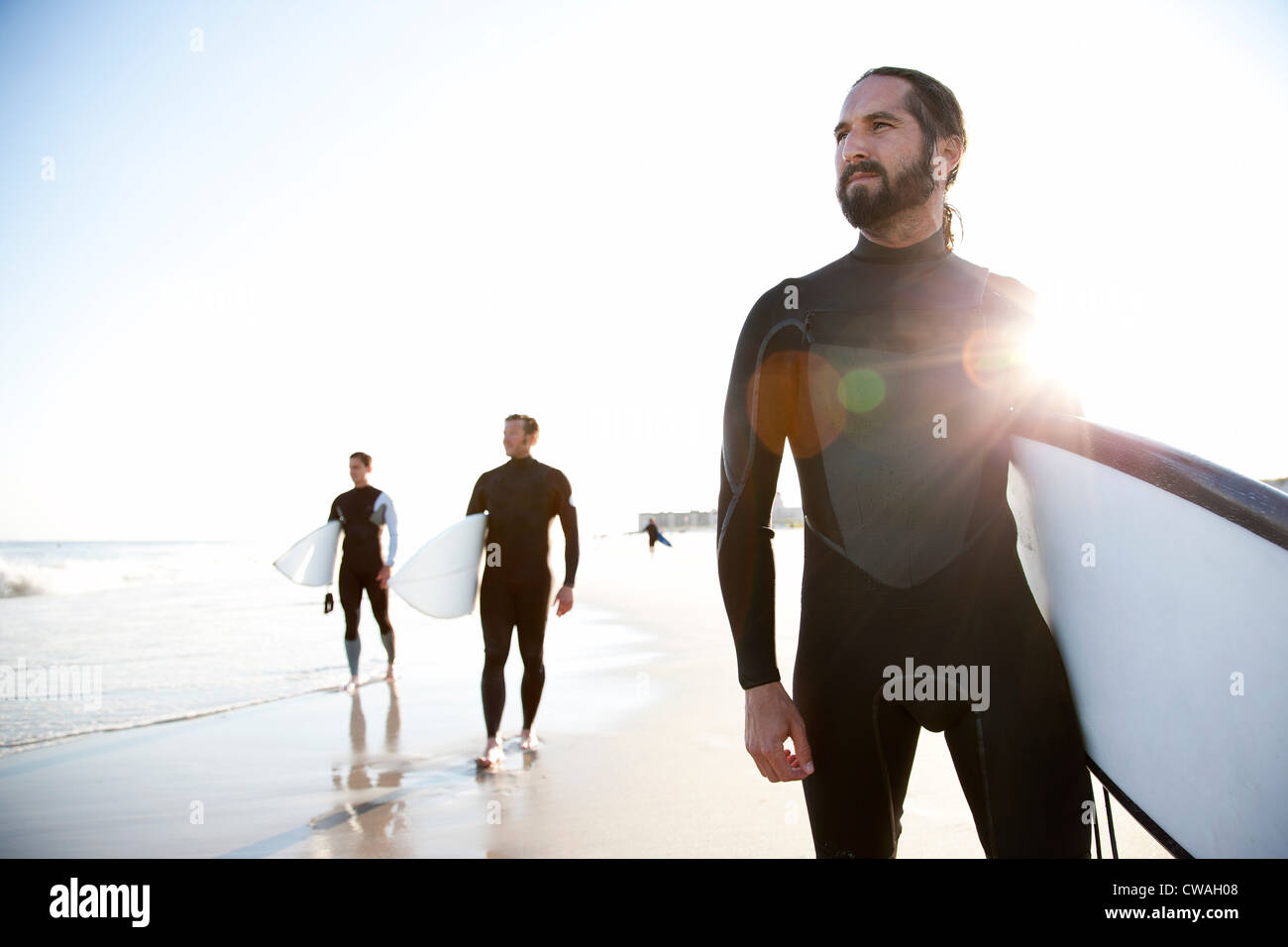 Three surfers at beach Stock Photo - Alamy