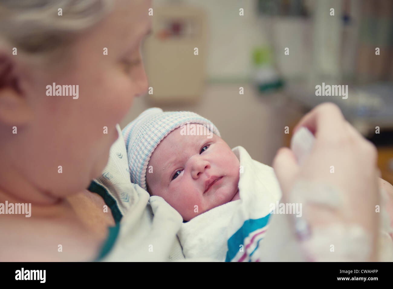 Mother cradling newborn baby girl Stock Photo - Alamy