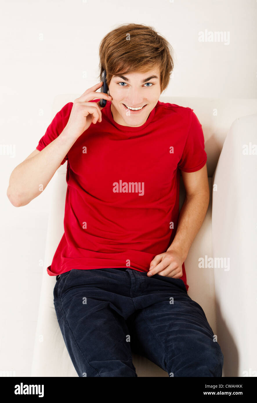 Handsome young man on the couch talking on cellphone Stock Photo - Alamy