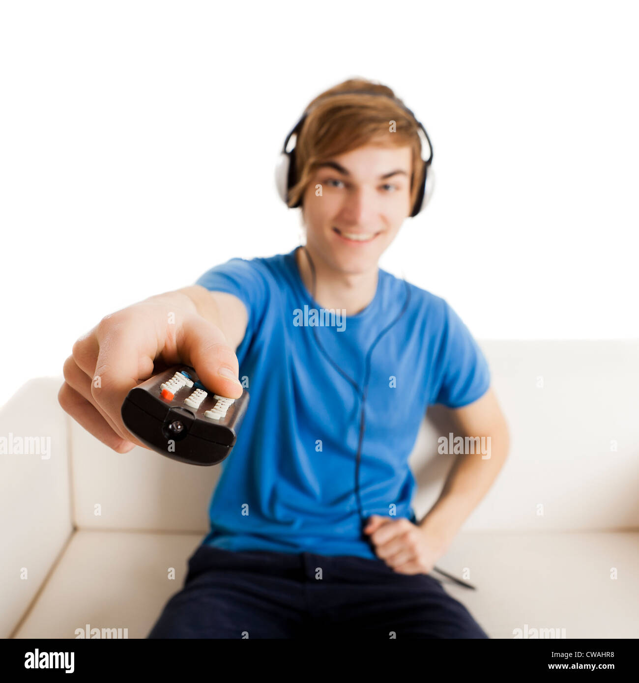Young man sitting on the couch using a remote control Stock Photo - Alamy