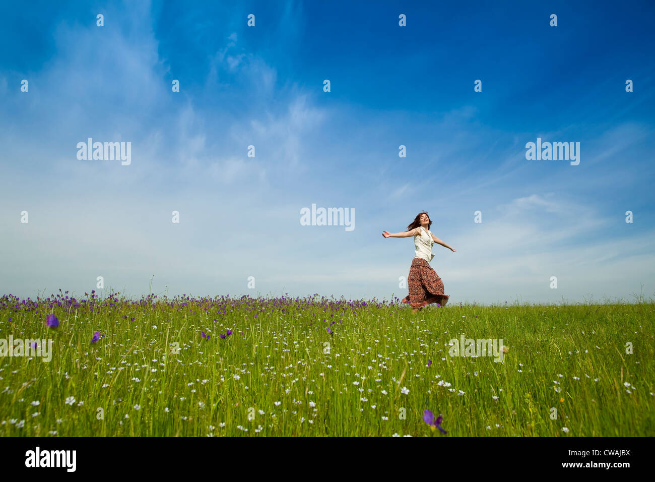 Young woman dancing on a beautiful green meadow Stock Photo - Alamy
