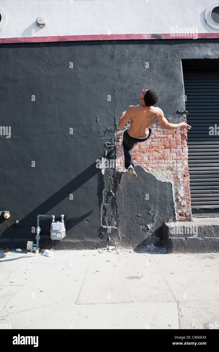 Man running up wall, demonstrating parkour Stock Photo - Alamy