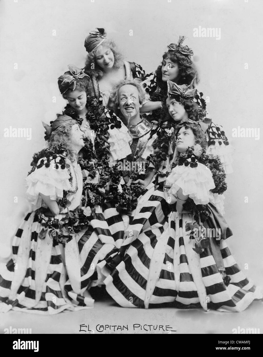 DeWolf Hopper, (1858-1935) surrounded by six women, all in costume ...