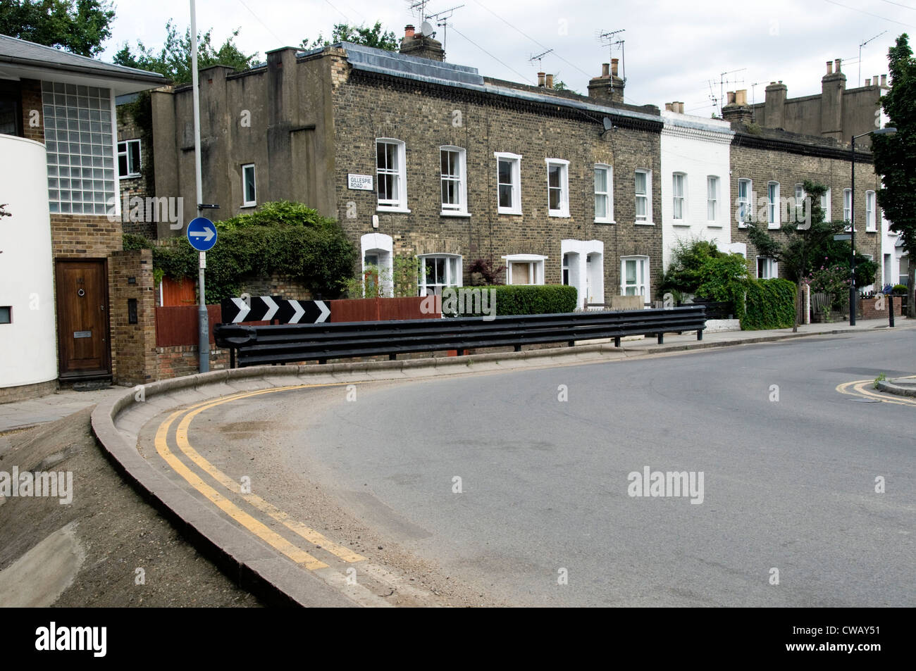 Sharp bend in road of residential street showing terraced houses and ...