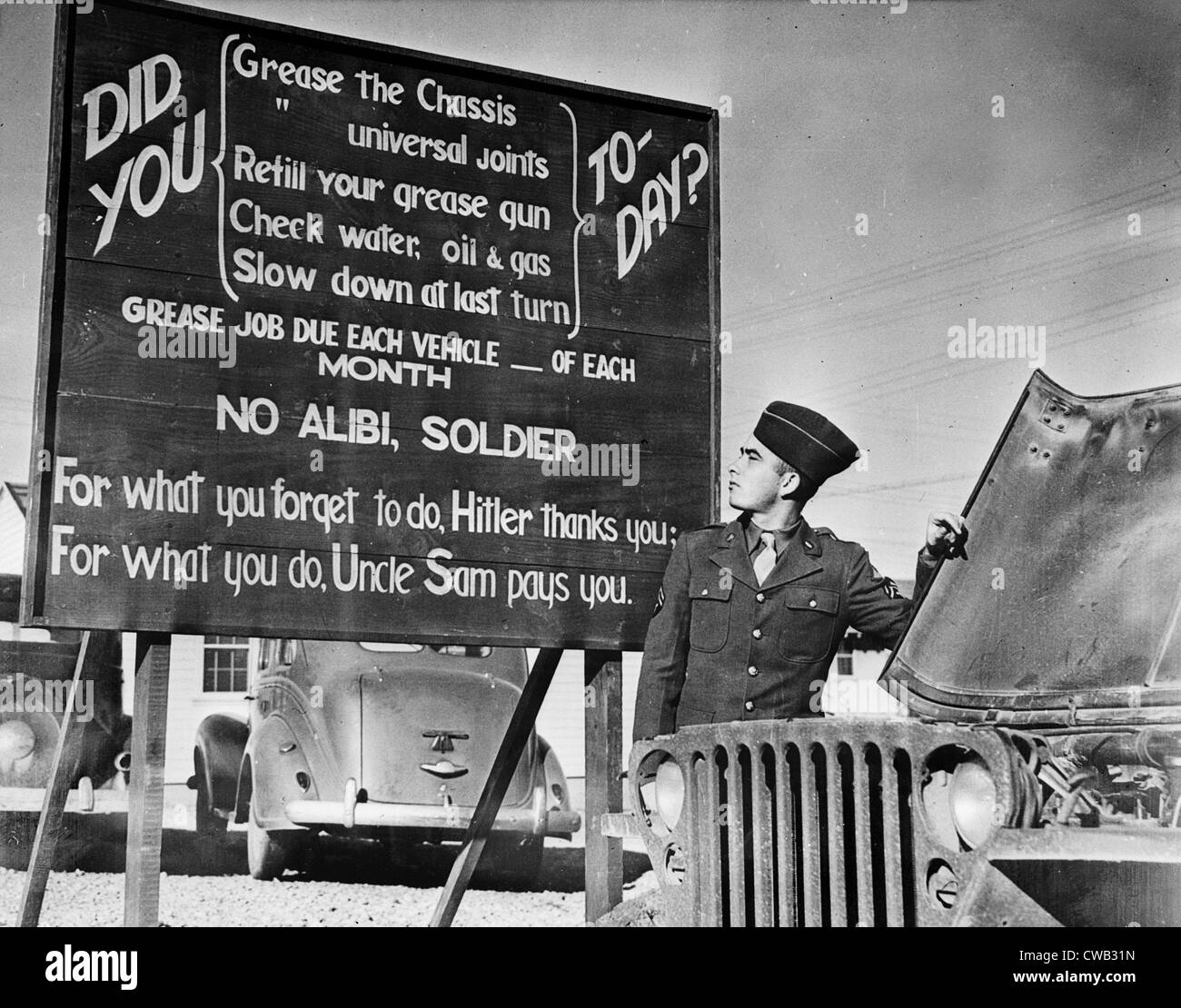 World War II, U.S. soldier at base in front of patriotic message, circa ...