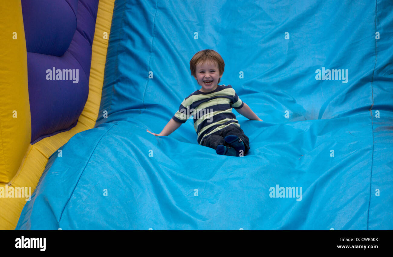 Young boy (3 years 10 months) having fun on an inflatable slide Stock ...
