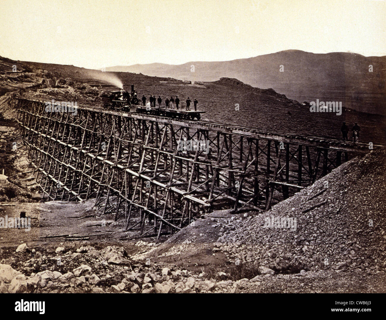Trestle work. Central Pacific Railroad construction workers standing on ...