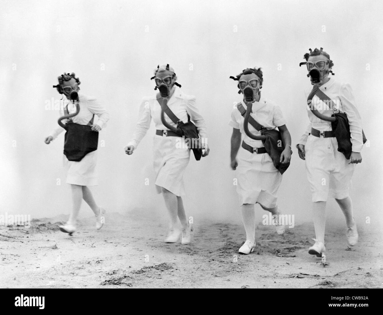 Nurses in gas masks walk through a cloud of smoke in a training drill ...