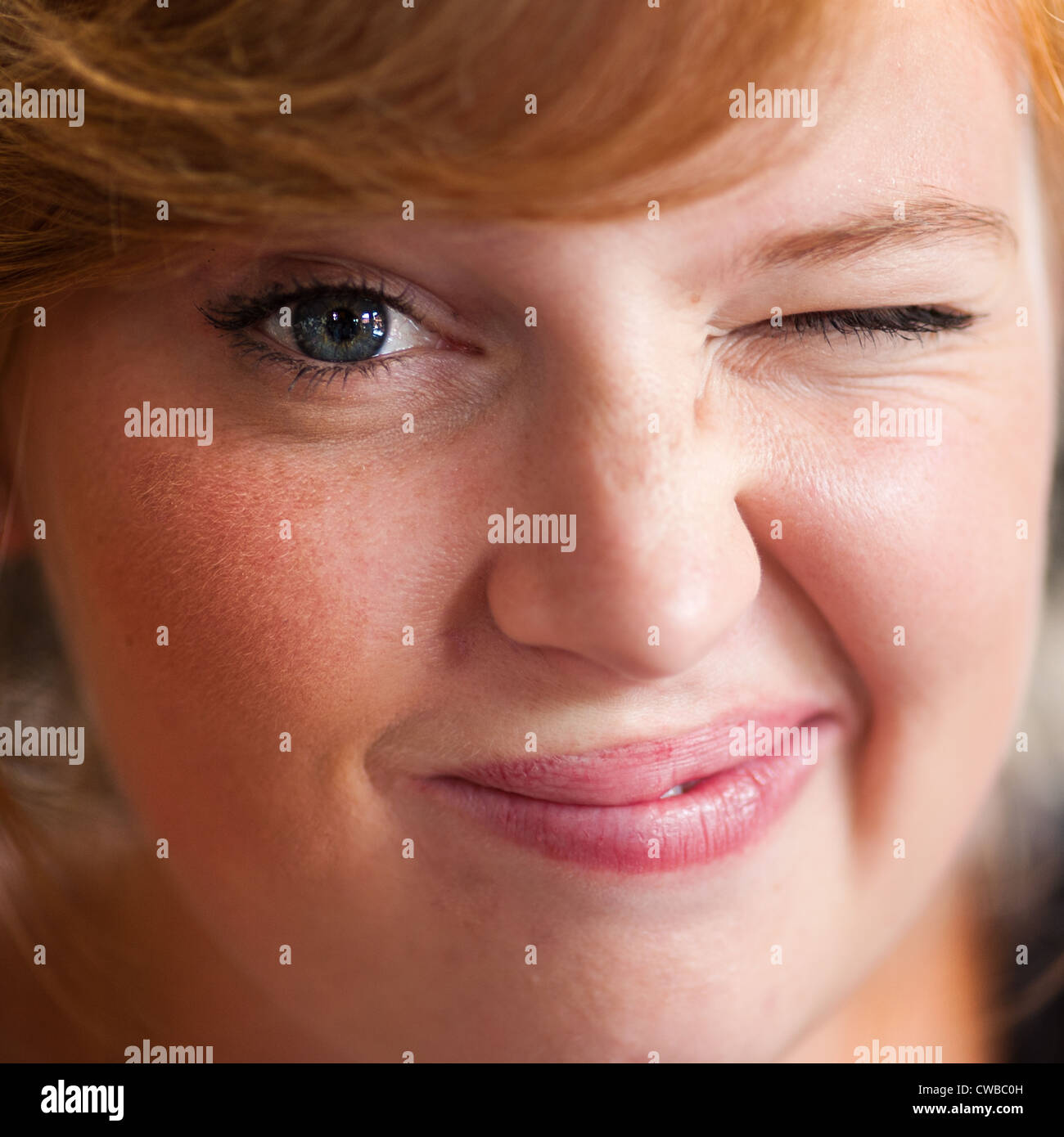 Young woman's face with winking eye Stock Photo - Alamy