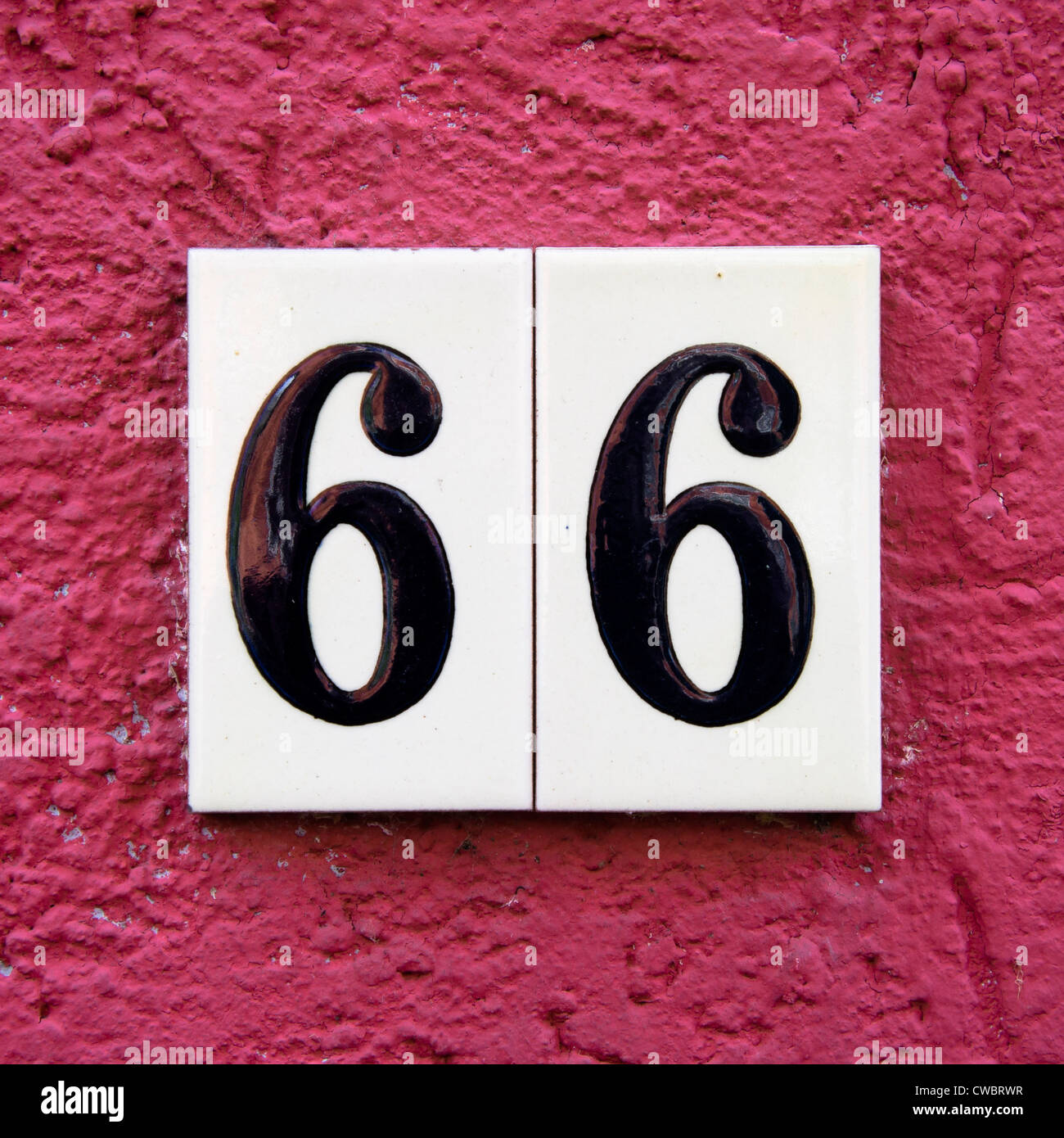 house number sixty-six. Black lettering on ceramic tiles against a pink ...