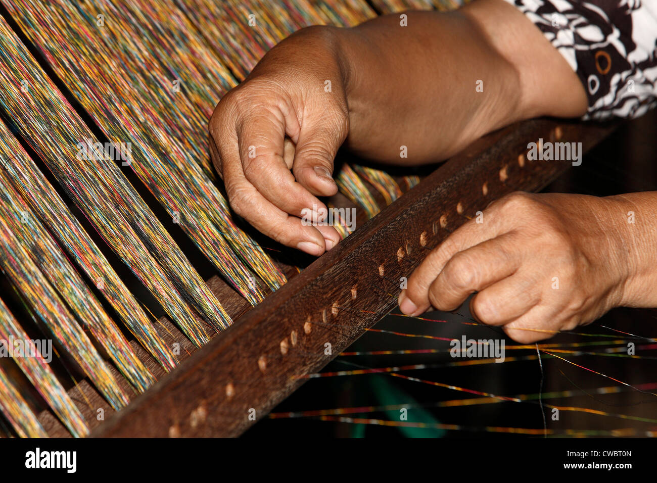 A process of Ikat fabric weaving. Separating the multicolored weft ...