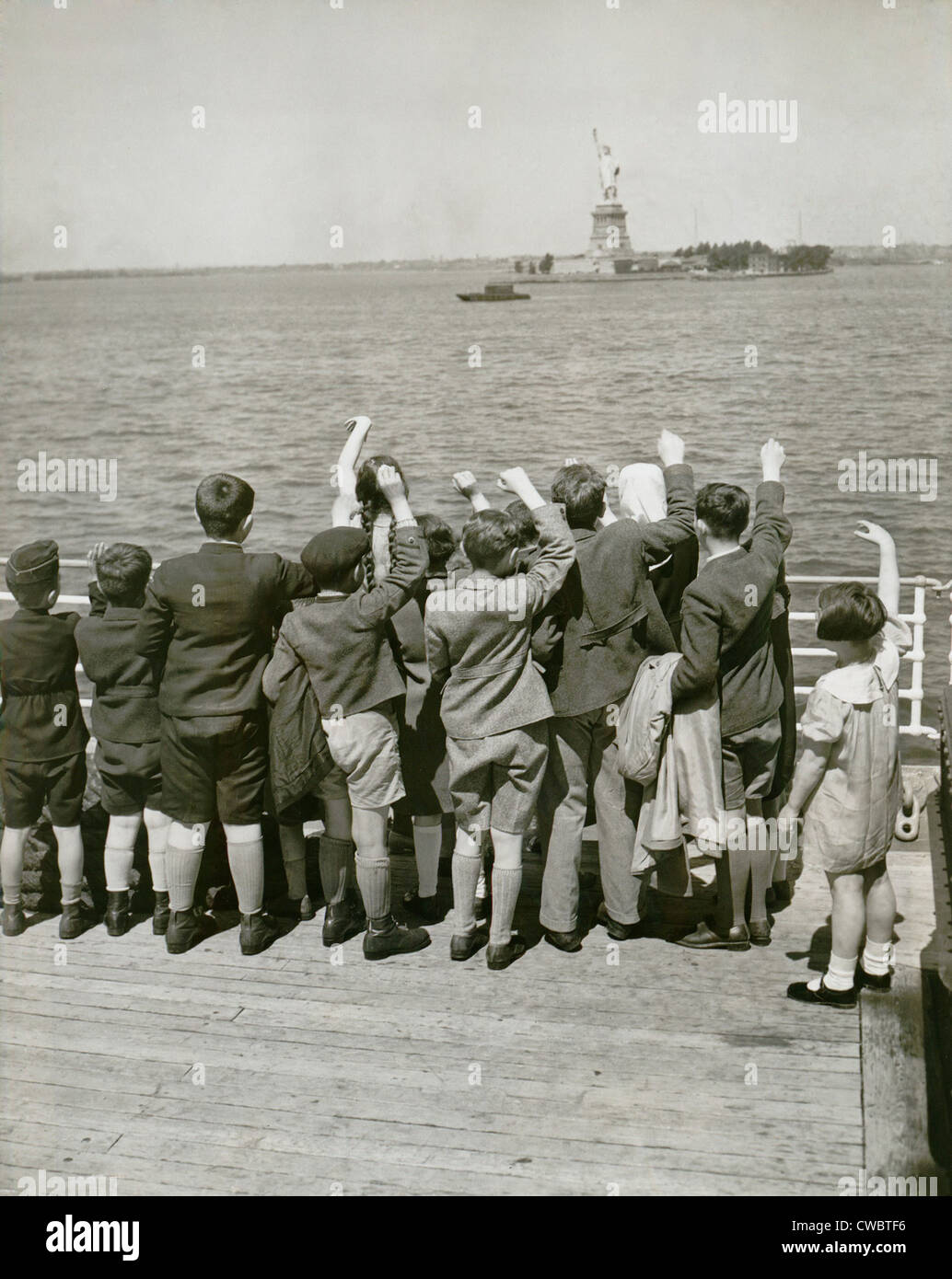 Jewish refugee children waving at the Statue of Liberty from the deck ...
