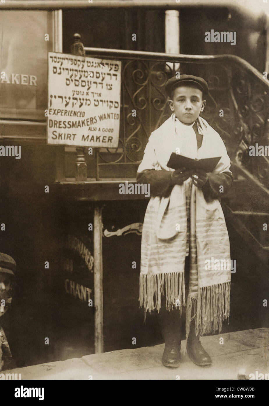 Jewish boy wearing a prayer shawl and boy reading from a Hebrew Bible ...