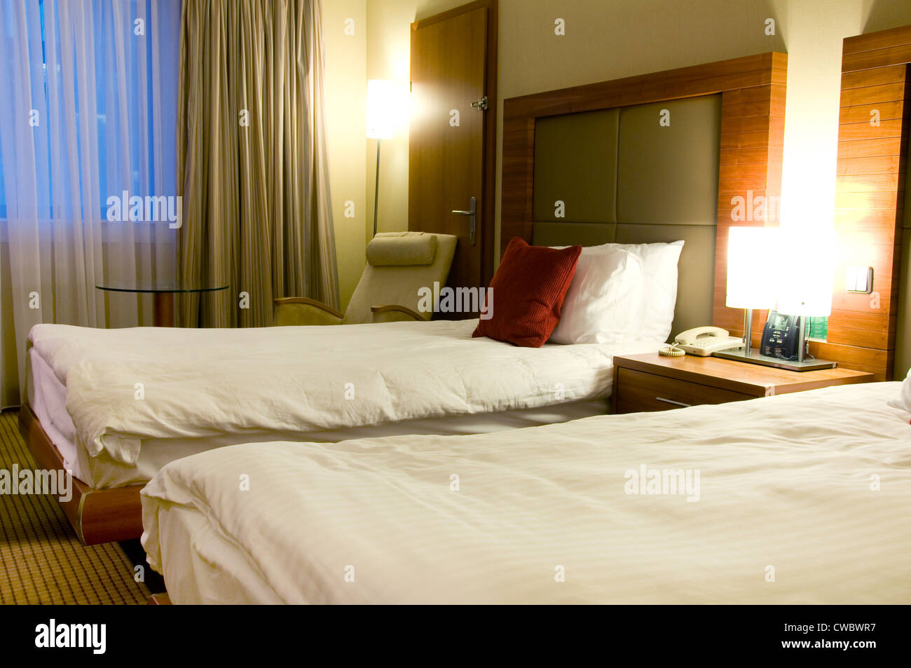 Hotel room with two beds covered by white bedclothes at night Stock ...