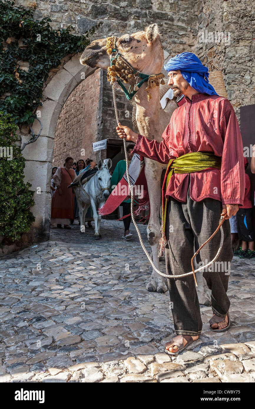 Moorish man with dromedary camel in a reenactment of a Medieval Fair in ...