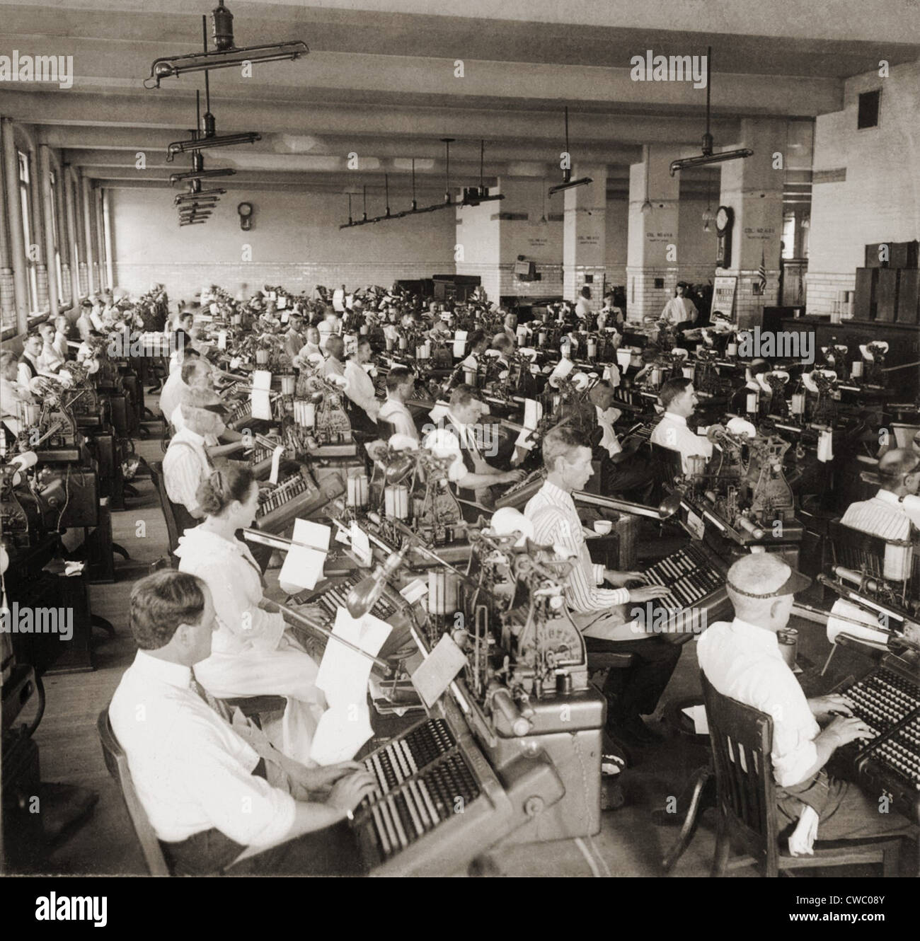 100 workers setting type on monotype machines, each with a 120-key ...