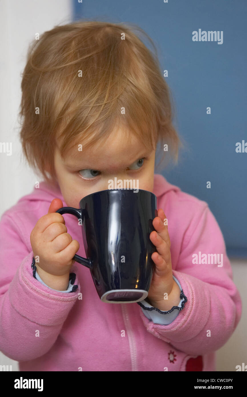 Girl drinking from a cup Stock Photo - Alamy