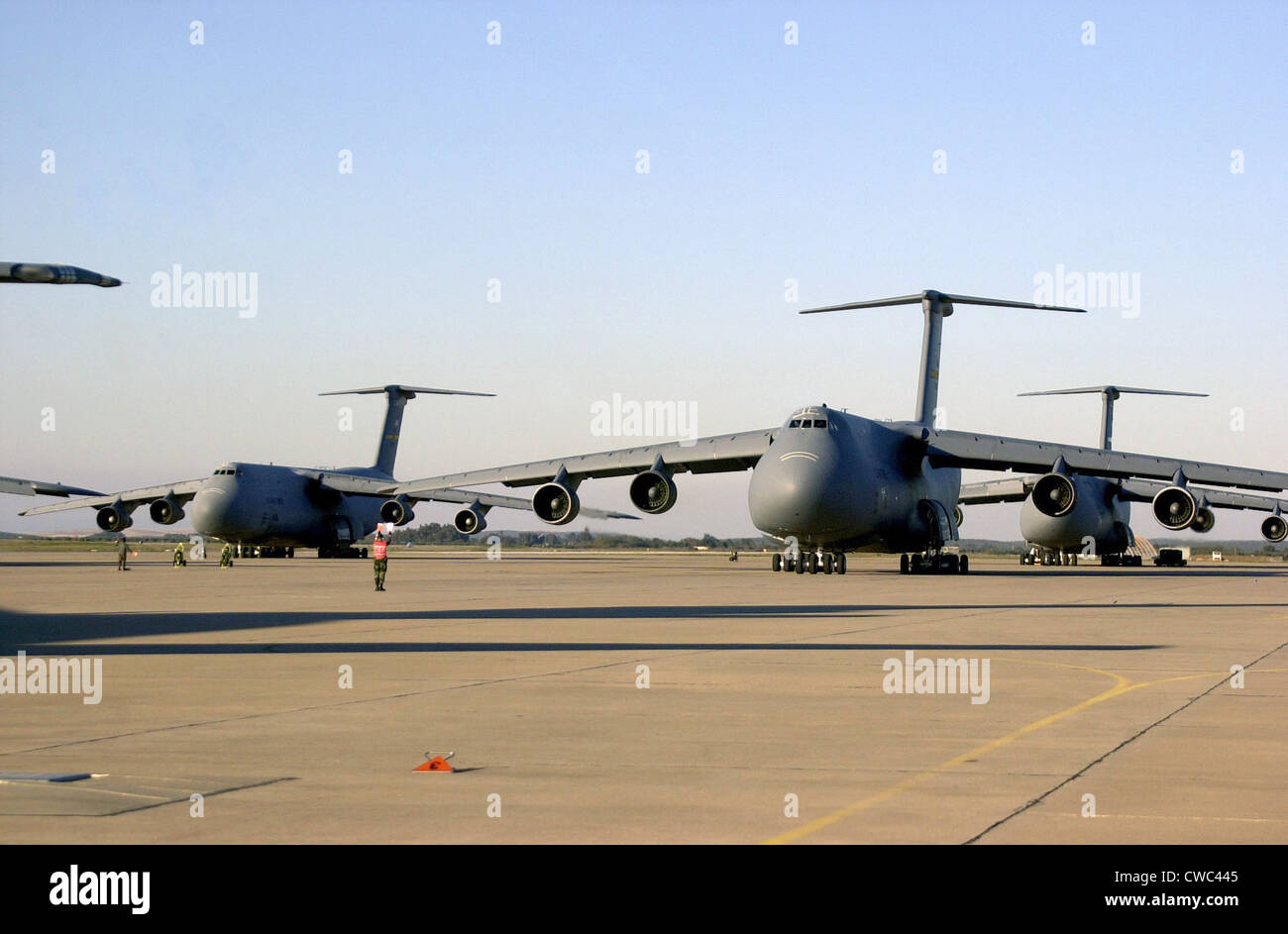 An U.S. airman dwarfed by a C-5 Galaxy cargo aircraft signals the plane ...