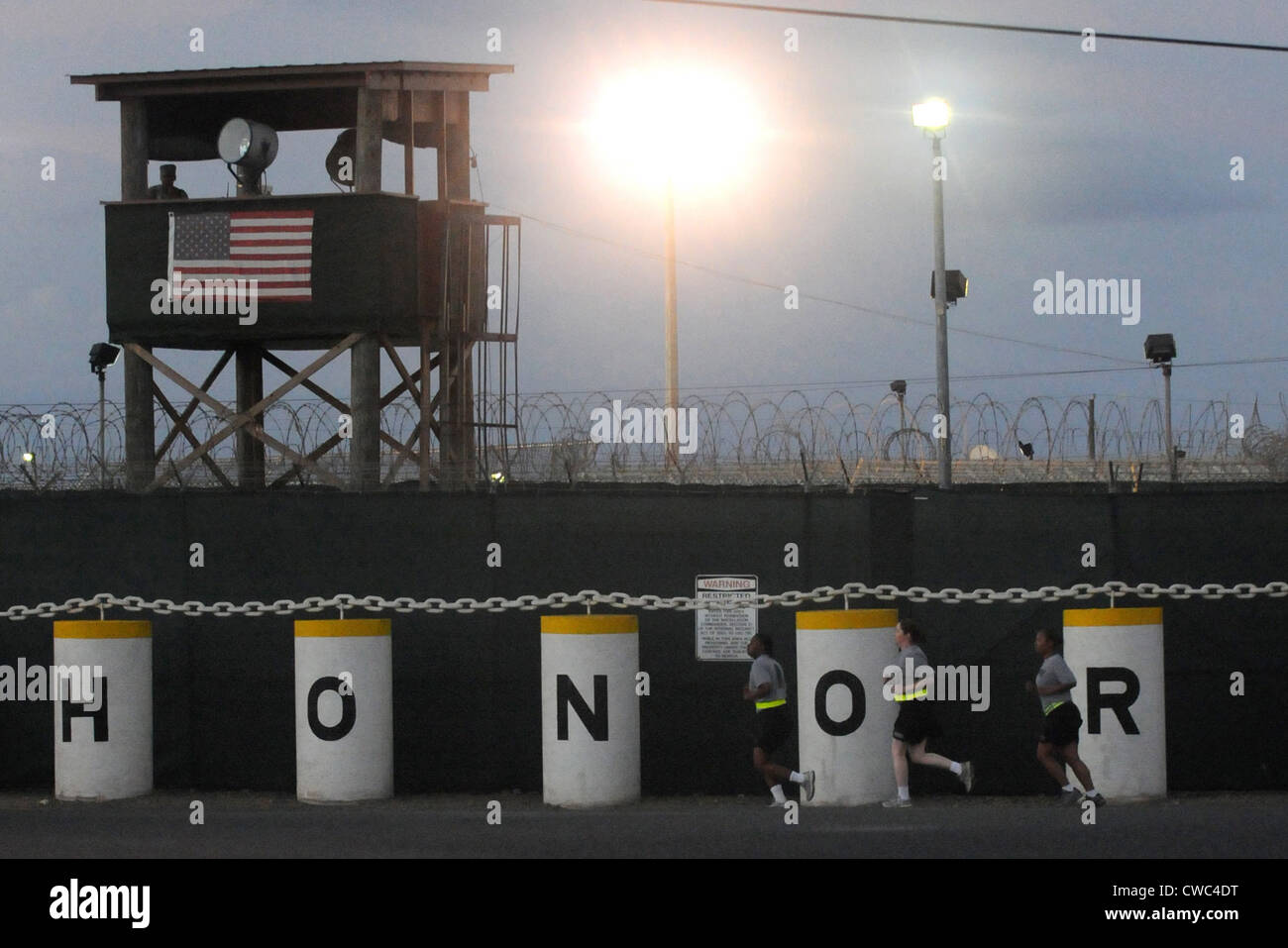 Female Military Police jog past a guard tower with a prominent American ...