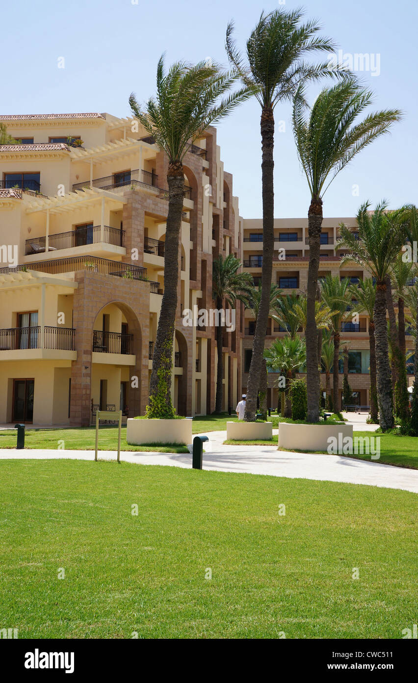 Outdoors view of a tropical resort with palm trees and green lawn Stock ...