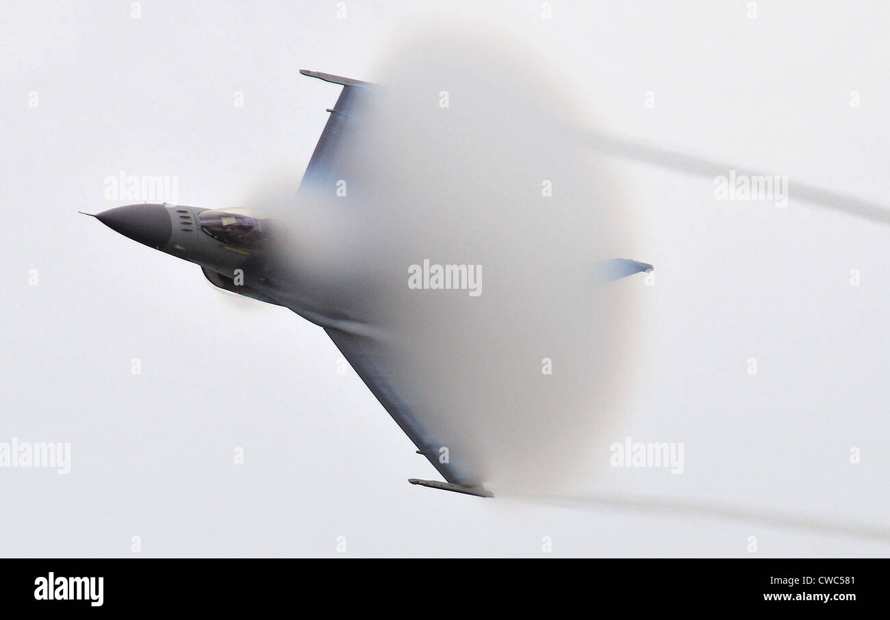 F-16 Fighting Falcon creates a vapor cone of condensation as it nears ...
