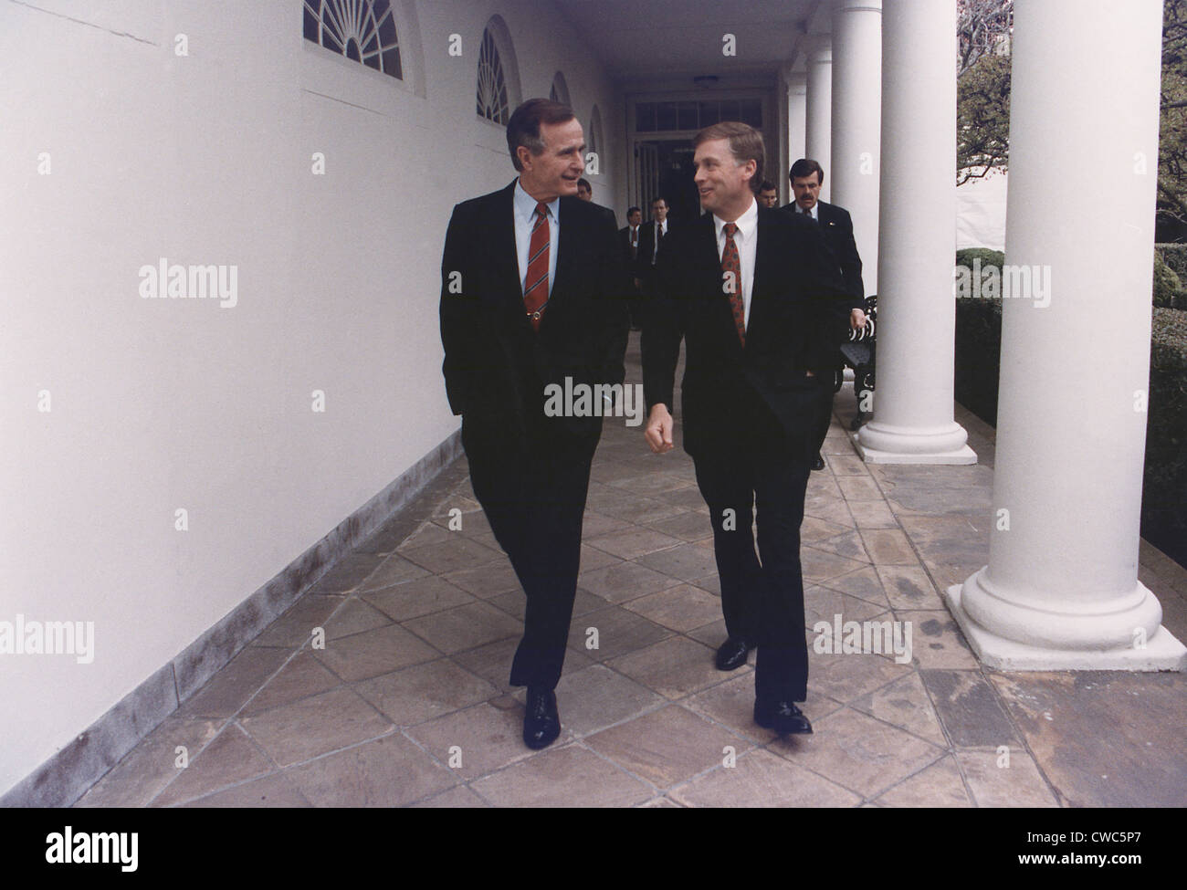 President George H.W. Bush walks along the West Wing colonnade with his ...