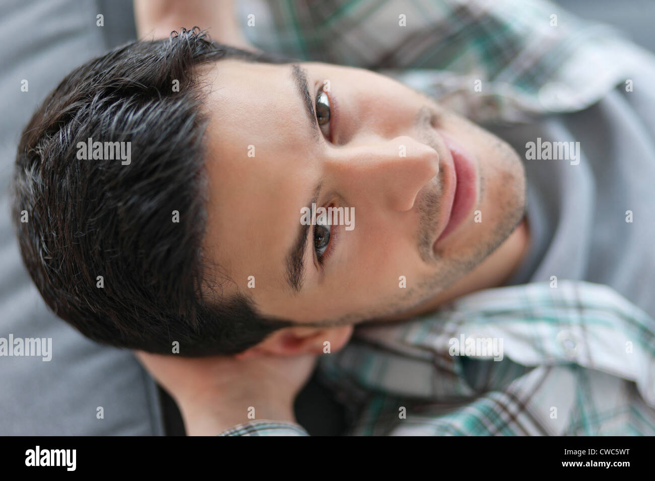Man lying on a couch and smiling Stock Photo - Alamy