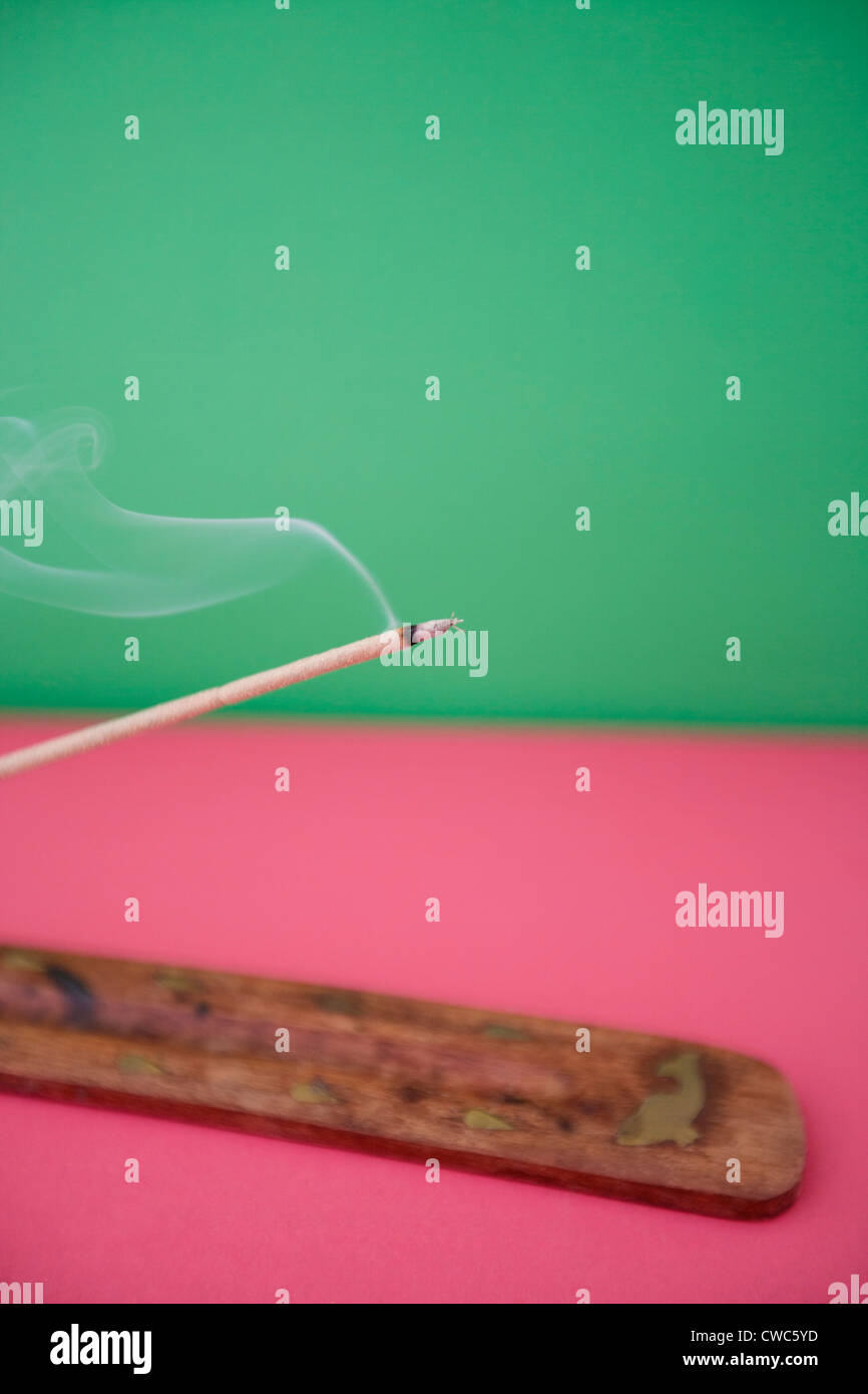 Close-up view of incense stick burning over colored background Stock ...
