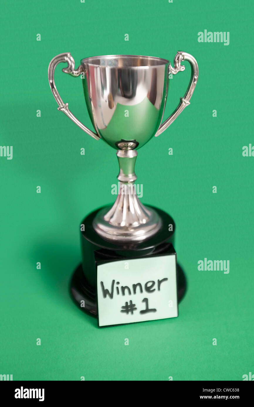 Trophy with sticky note for winner over colored background Stock Photo ...