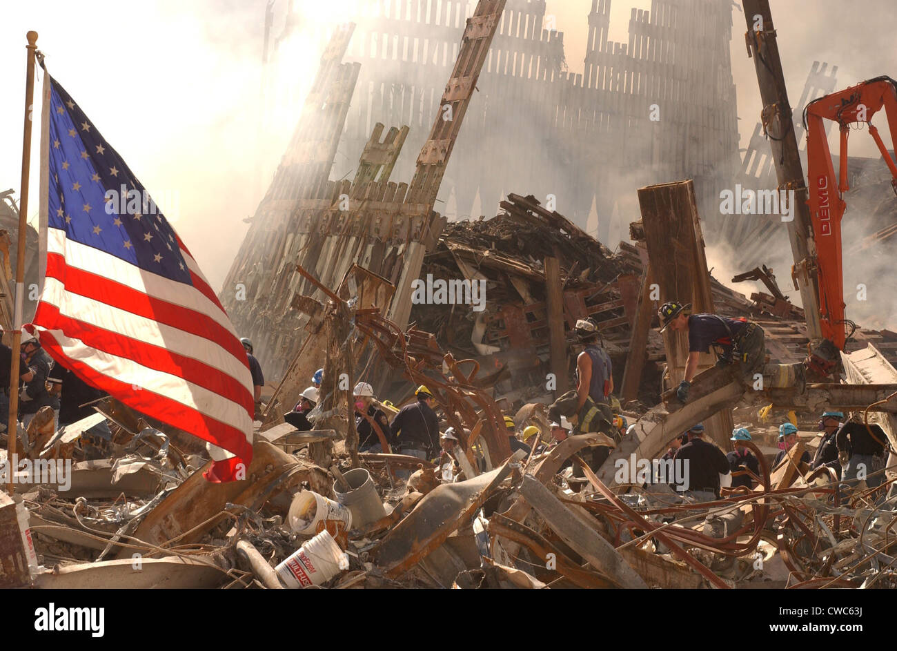 Rescue workers climb over and dig through piles of rubble from the ...