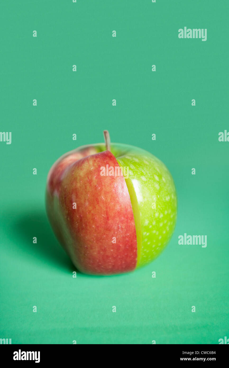Red and green apple slices joined together over colored background ...