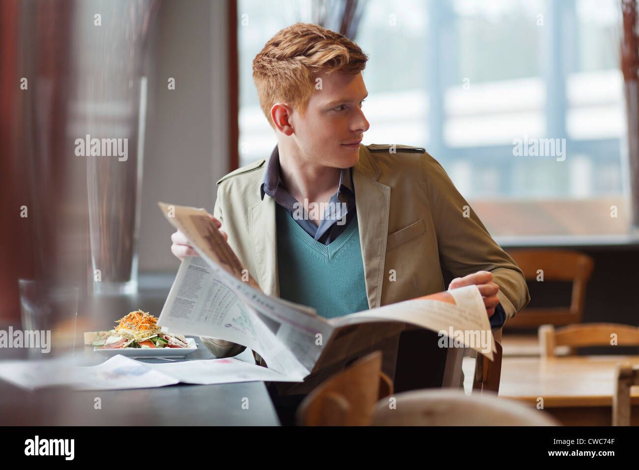 Man sitting in a restaurant and reading a newspaper Stock Photo - Alamy