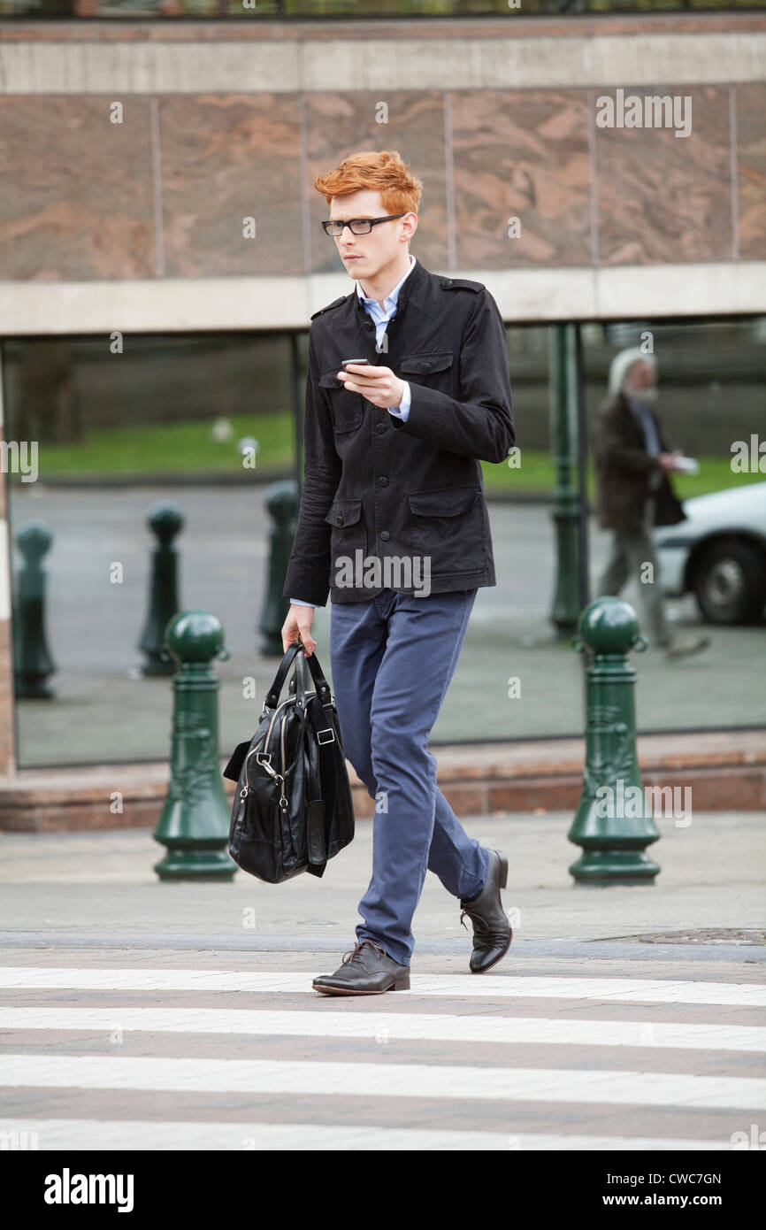 Man crossing the road while using a mobile phone Stock Photo - Alamy