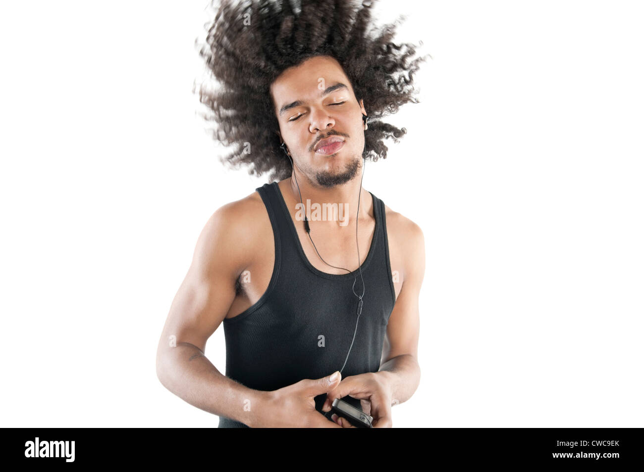 Young man shaking head while listening to mp3 player over white ...