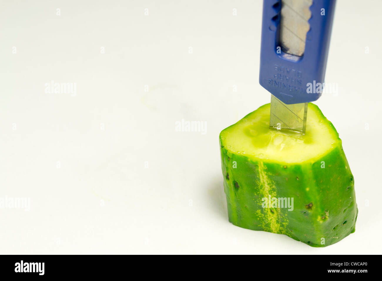 Wounded cucumber with a knife in the back Stock Photo - Alamy