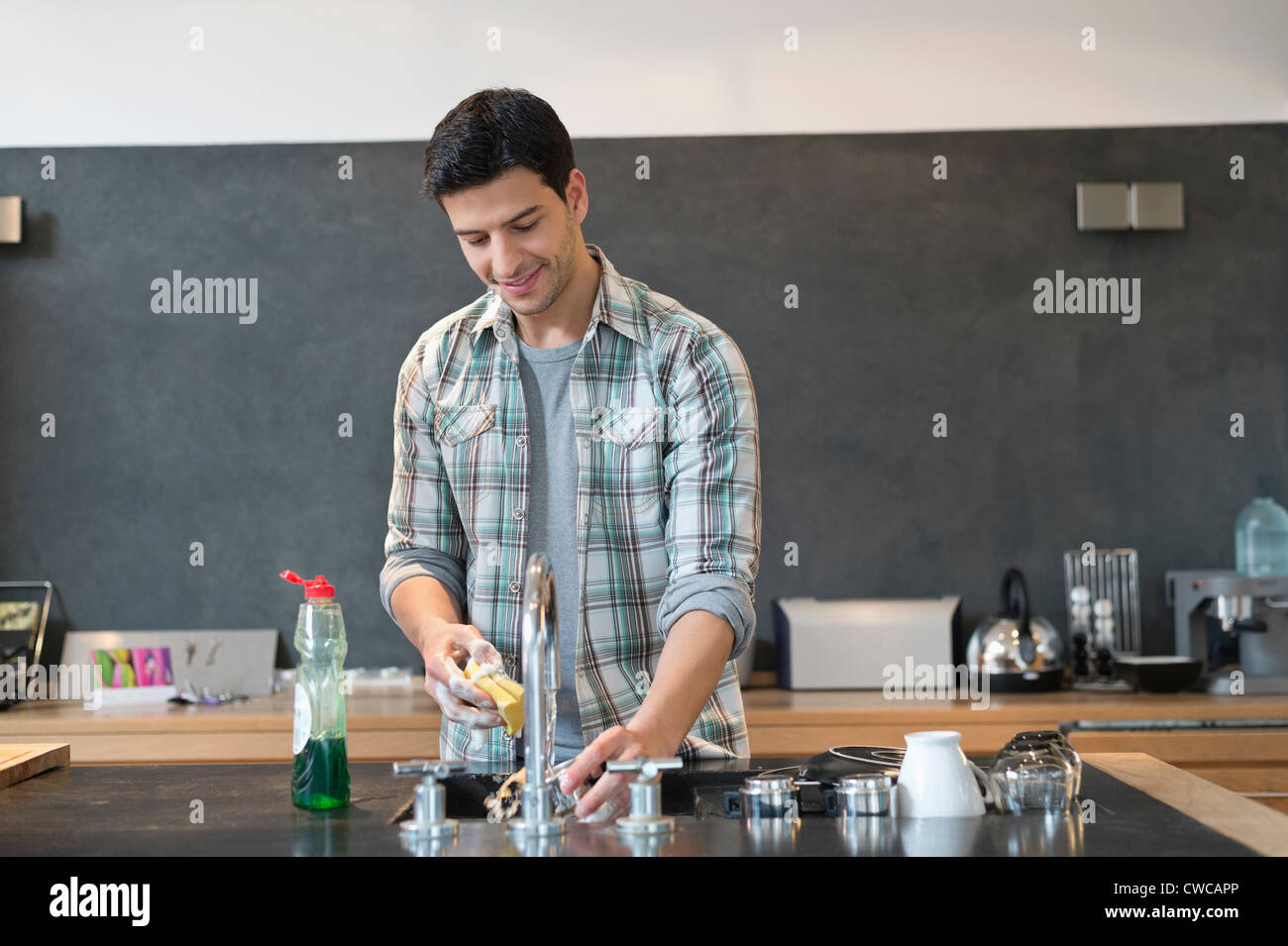 Man washing dishes in the kitchen Stock Photo - Alamy