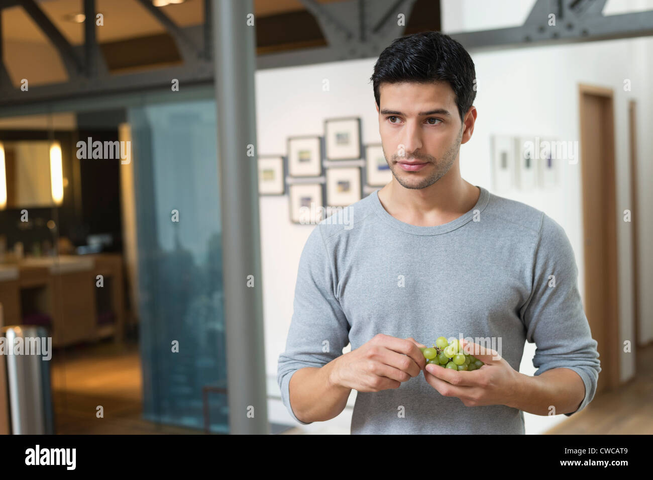 Man eating grapes Stock Photo - Alamy