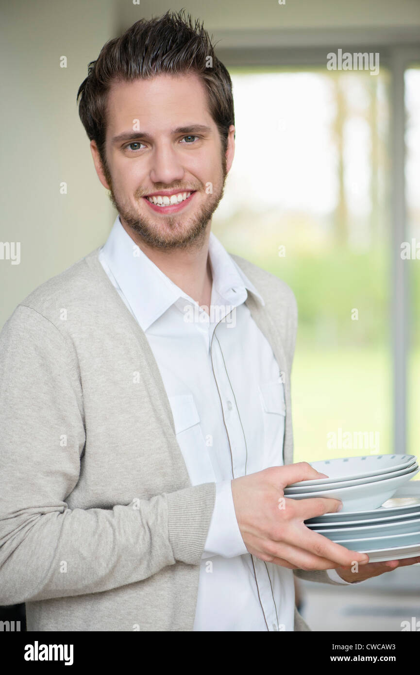 Portrait of a man carrying plates Stock Photo - Alamy