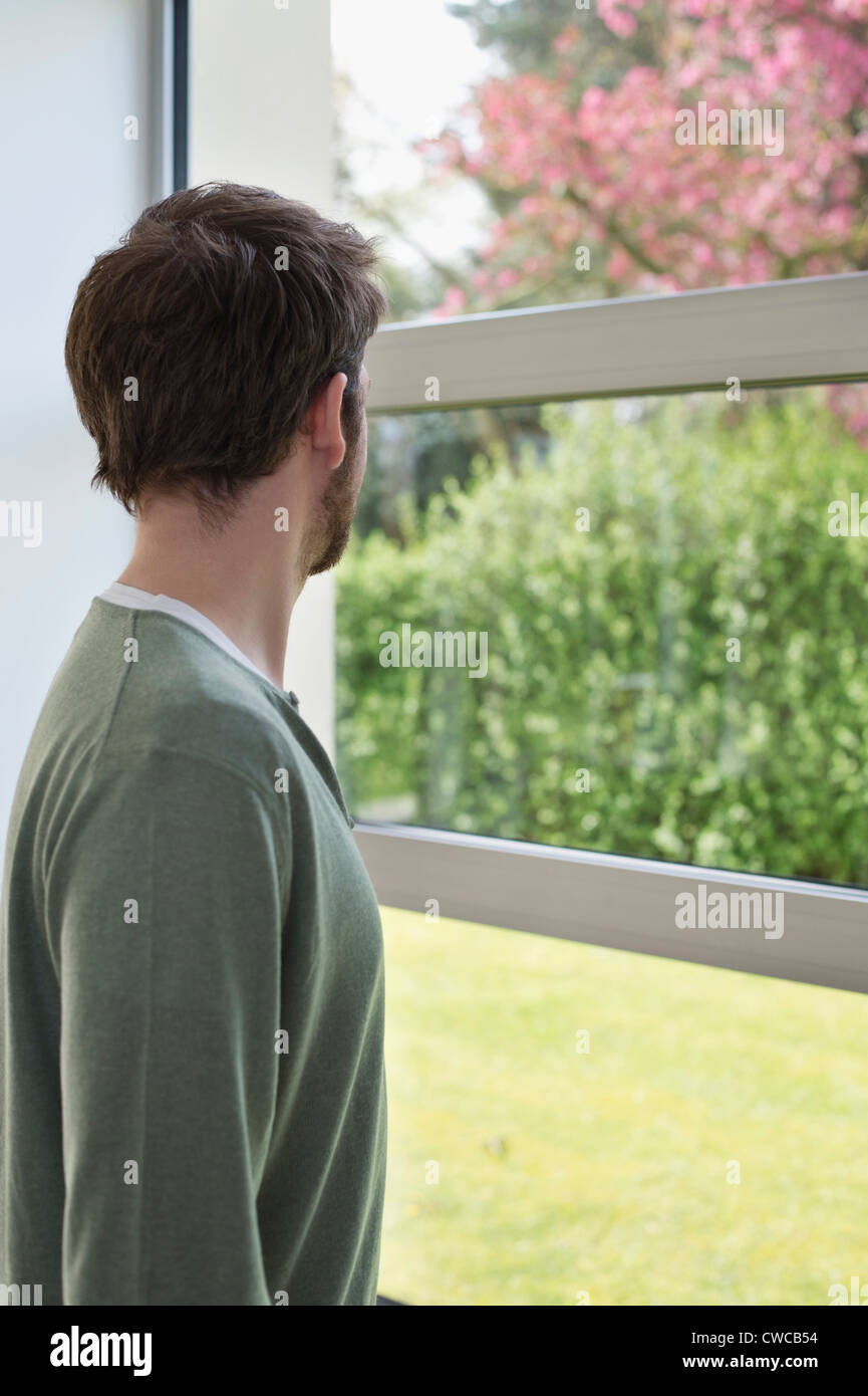 Man looking through a window Stock Photo - Alamy