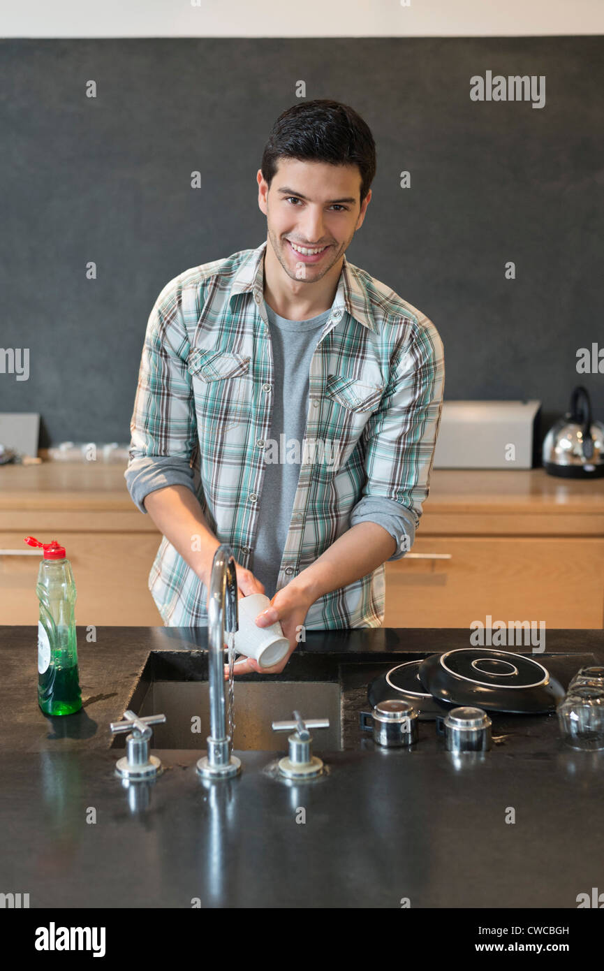 Portrait of a man washing dishes in the kitchen Stock Photo - Alamy