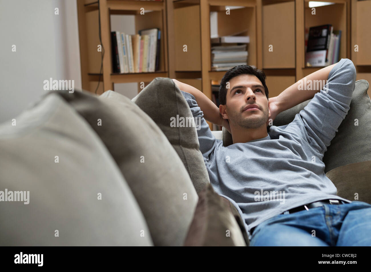 Man reclining on a couch Stock Photo - Alamy
