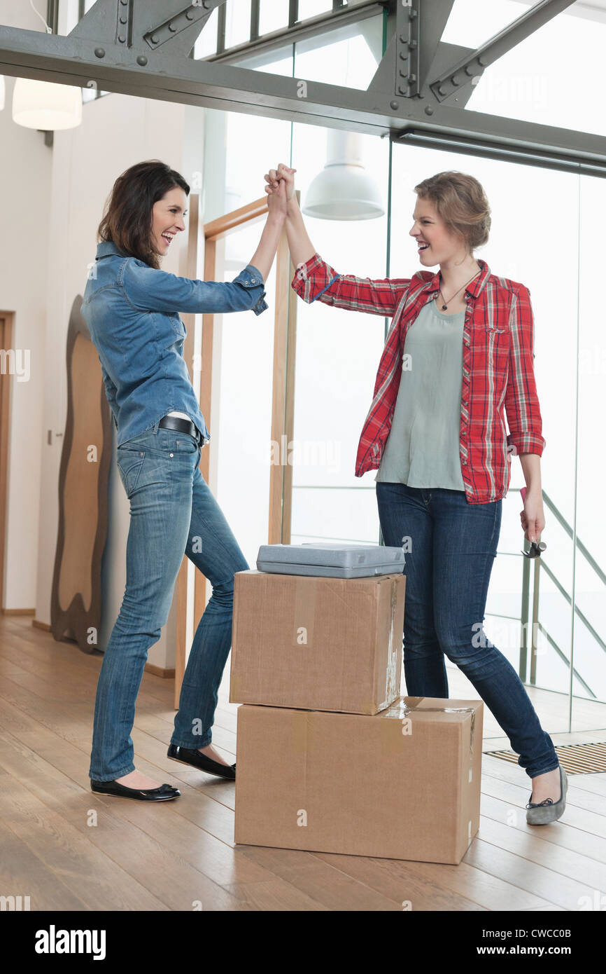 Two female friends giving high-five to each other Stock Photo - Alamy