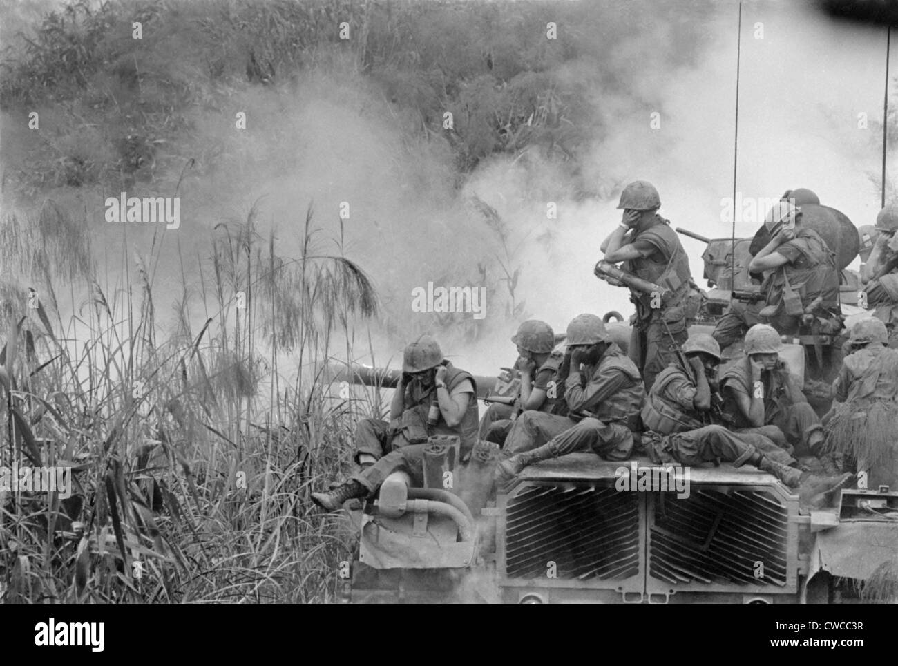 Vietnam War. Marines riding atop an M-48 tank cover their ears as the ...
