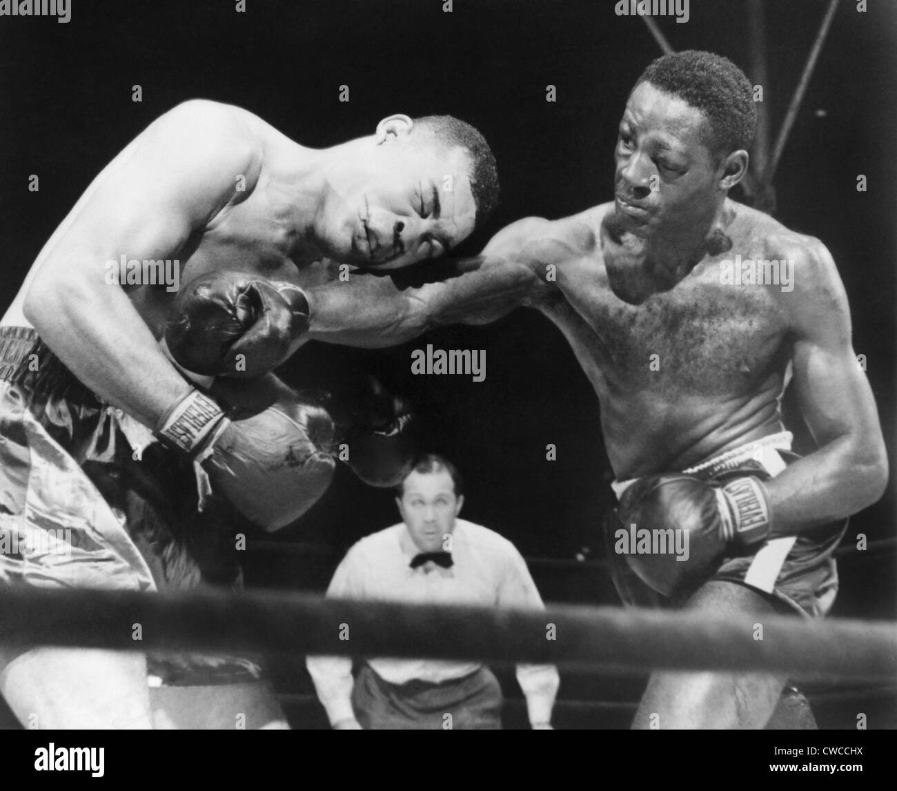 Joe Louis (left), takes a hard right punch in the midsection from ...