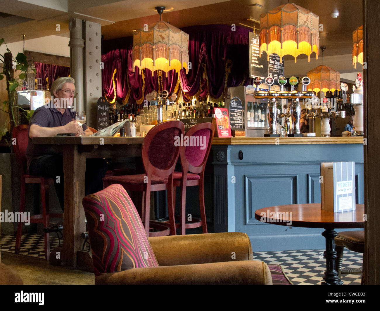 A Man reads a newspaper inside the Trafalgar pub - Chelsea, London ...