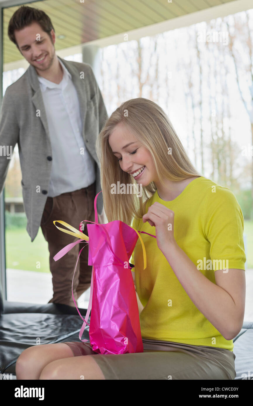 Happy woman opening a present given by her boyfriend Stock Photo - Alamy