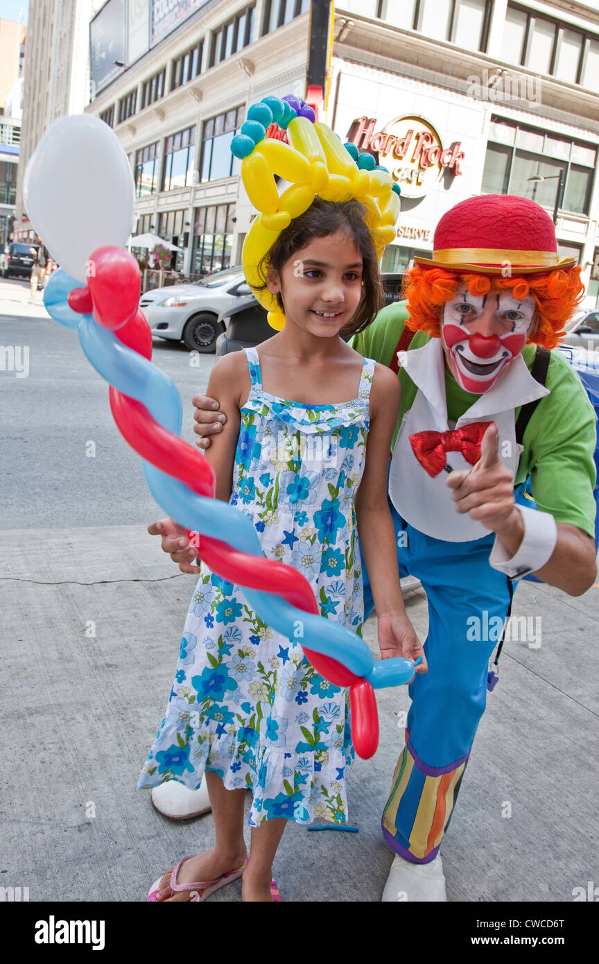 Balloon Clown is entertaining a little Girl on Yonge Street in Toronto ...